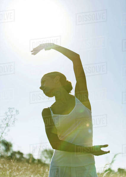 Woman dancing in field - Stock Photo - Dissolve