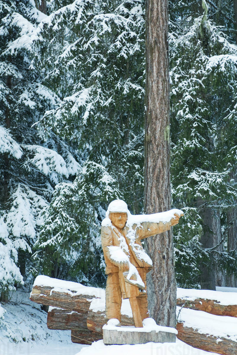 Wooden lumberjack by timber in snow - Royalty-free Stock Photo | Dissolve