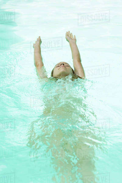 Woman swimming backwards in pool - Stock Photo - Dissolve