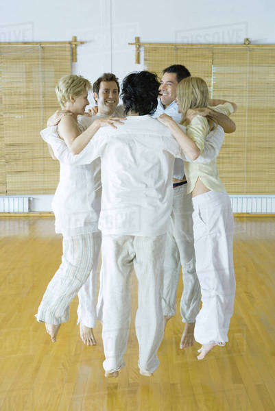 Group of adults holding onto each others' shoulders, jumping - Stock ...