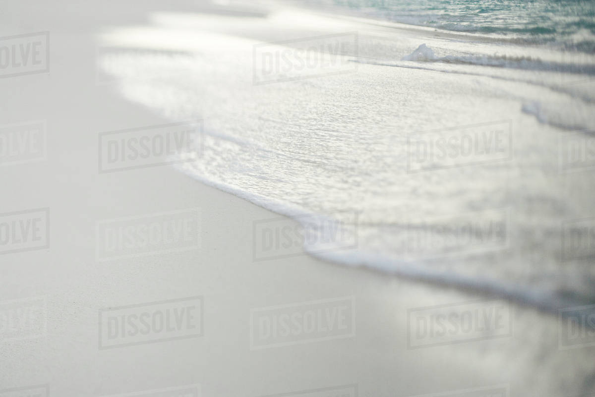Surf washing up on sand, close-up - Stock Photo - Dissolve