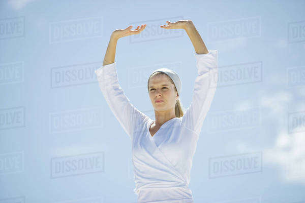 Young woman with arms over head, low angle view - Royalty-free Stock ...