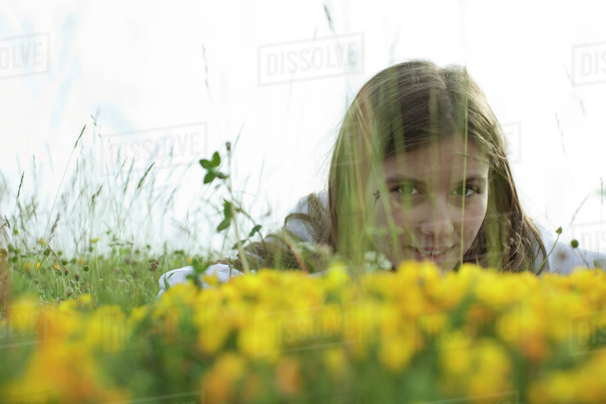 Young woman lying in meadow, portrait - Stock Photo - Dissolve
