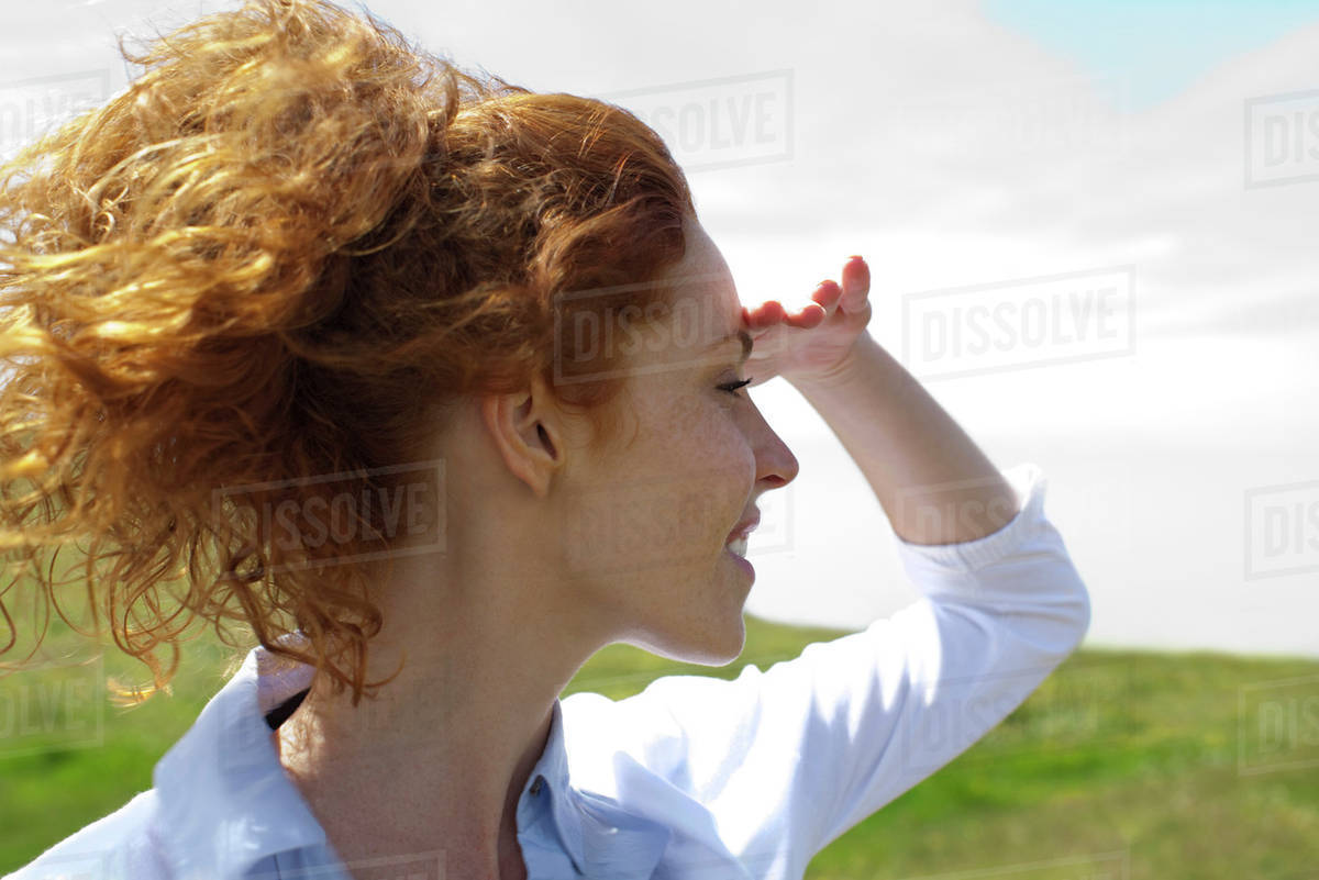 Young woman looking into distance, hand shading eyes - Stock Photo ...