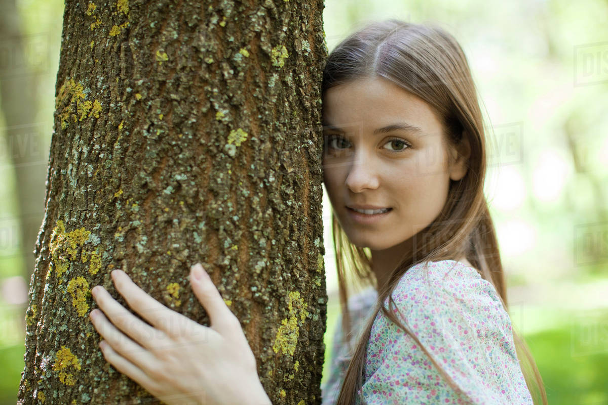 Young woman hugging tree, portrait - Royalty-free Stock Photo | Dissolve