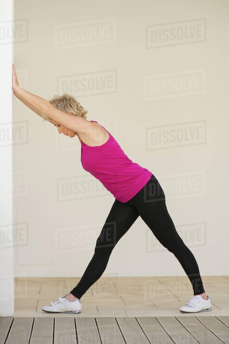 Mature woman pushing against wall, side view - Royalty-free Stock Photo ...
