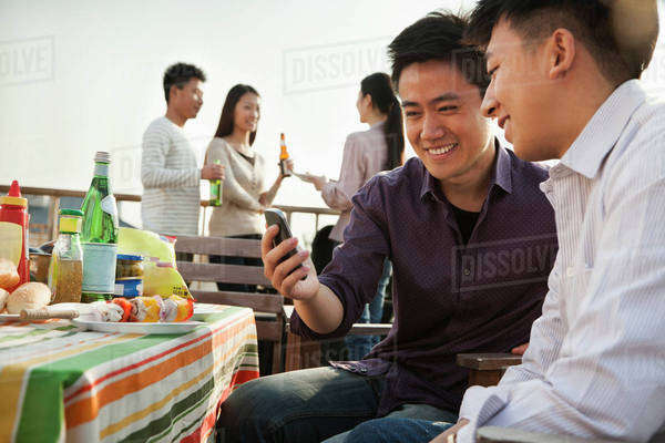 Friends Using Cell Phone at Rooftop Barbecue - Royalty-free Stock Photo ...