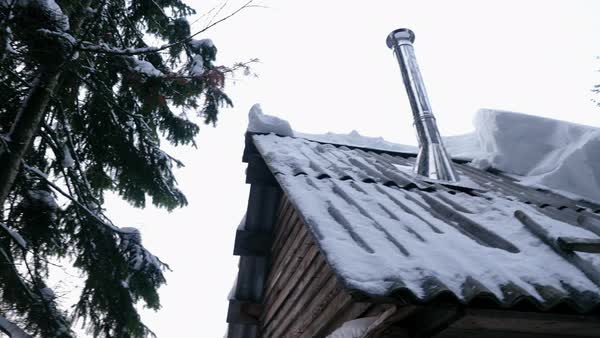 Close-up shot of smoke coming from a chimney on the roof of an ...