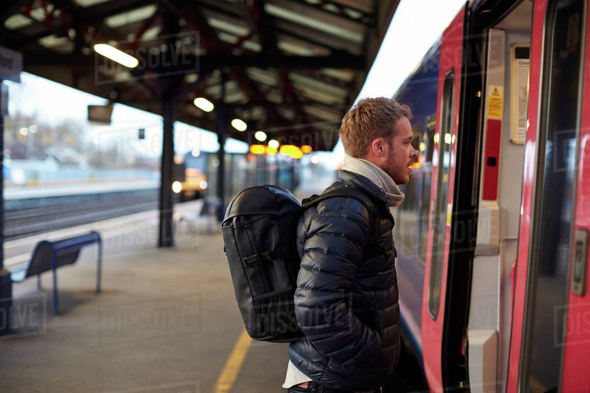 Man standing on railway platform waiting to board train - Royalty-free ...
