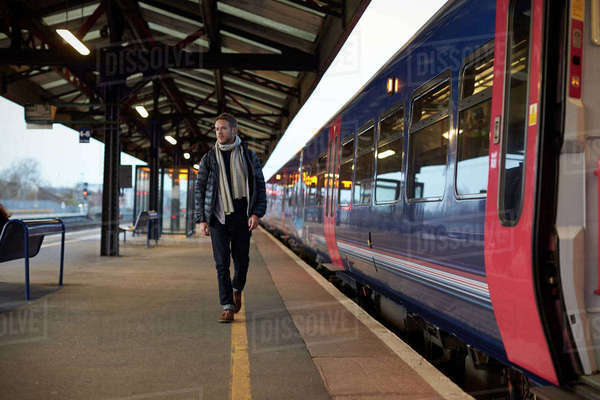 Man standing on railway platform waiting to board train - Stock Photo ...