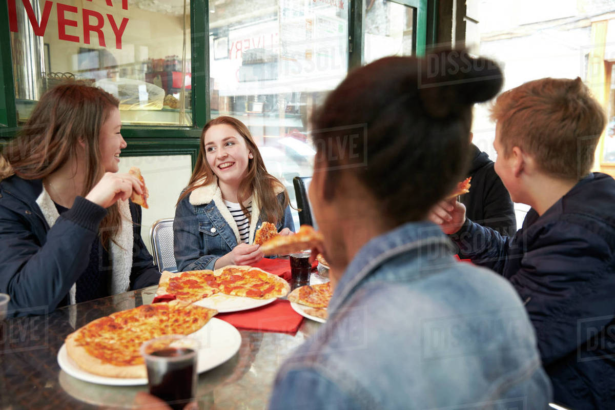 Group of teenagers eating pizza in cafe - Royalty-free Stock Photo ...