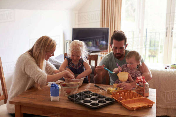 Family at home baking cakes together - Royalty-free Stock Photo | Dissolve