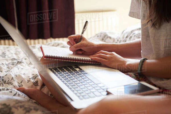 Close Up Of Woman Sitting On Bed Using Laptop Computer - Royalty-free ...