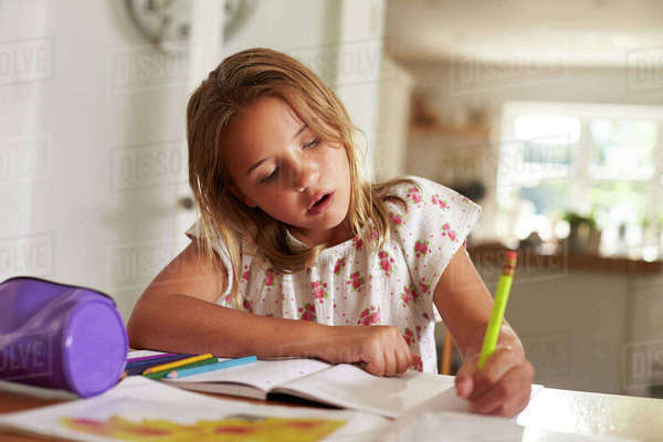 Girl concentrating on writing her homework - Royalty-free Stock Photo ...