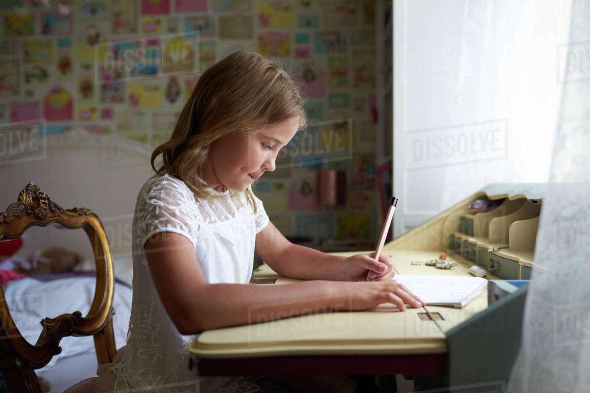 Young girl sitting at desk and writing in bedroom - Royalty-free Stock ...