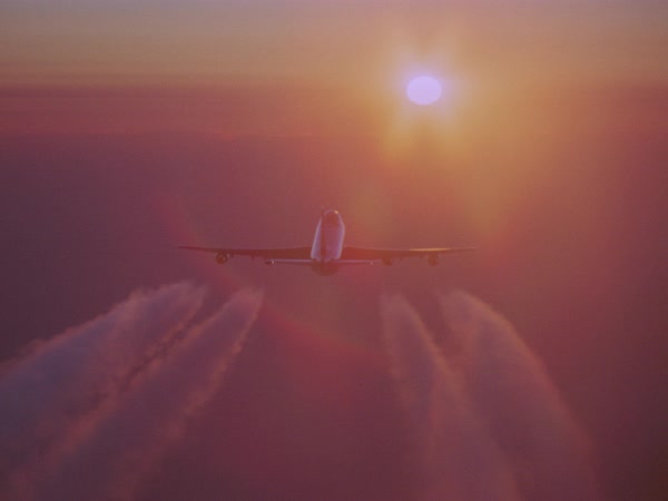 Boeing 747 commercial passenger airplane flying above clouds at sunset ...