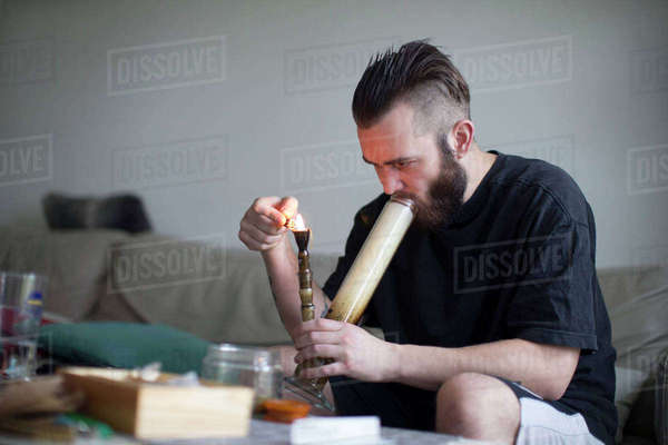 Young man smoking drugs in bong at home - Royalty-free Stock Photo ...