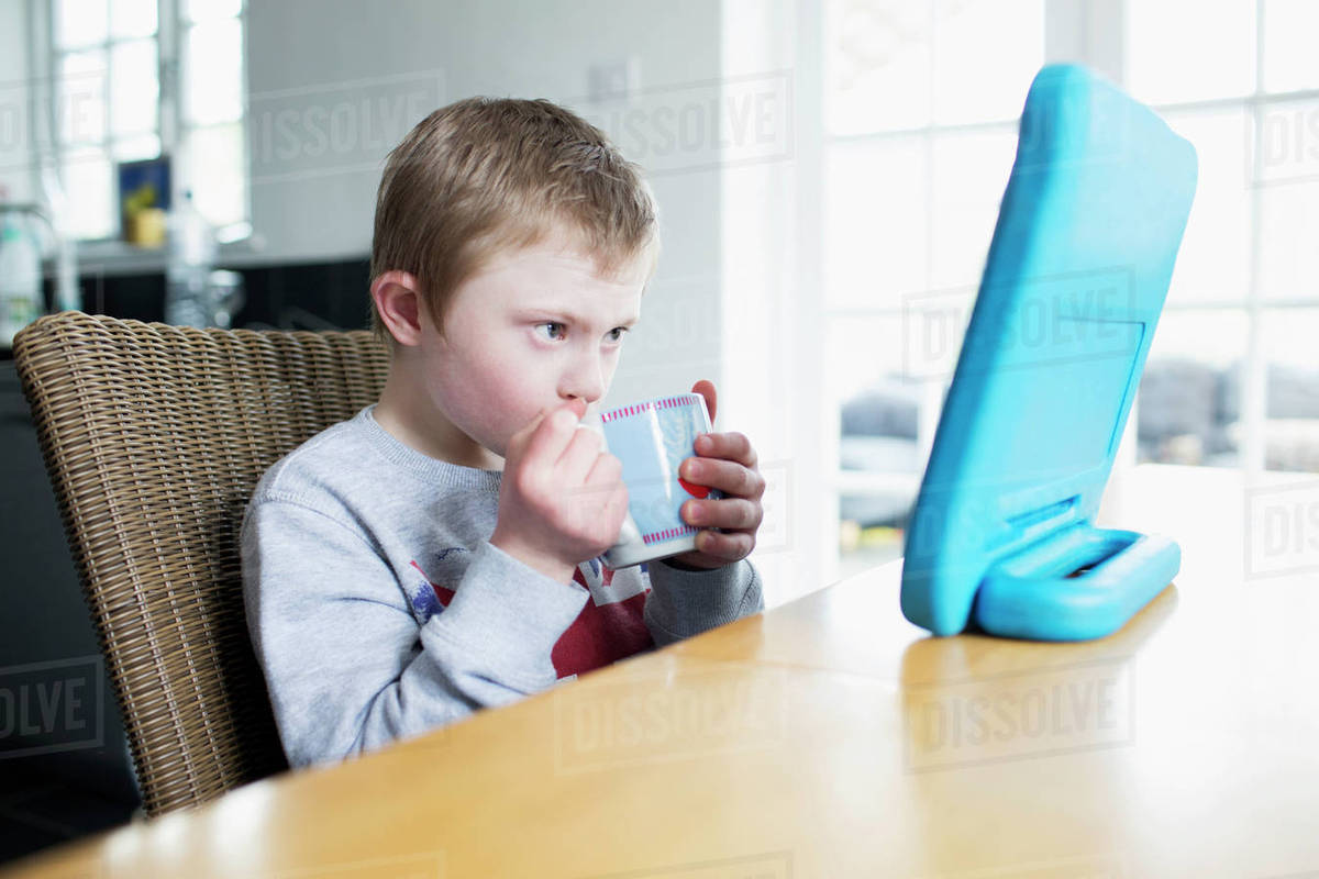 Boy using computer at home - Stock Photo - Dissolve
