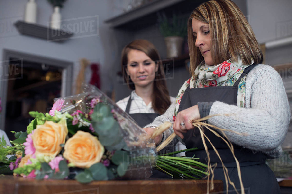 Female florists working on bouquet in shop - Royalty-free Stock Photo ...