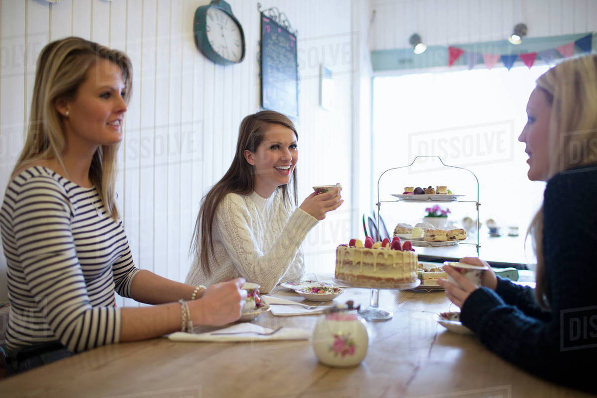 Group of young female friends meeting in tea shop - Stock Photo - Dissolve