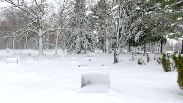 Beautiful snow covered cemetery, graveyard, tombstones, after blizzard ...