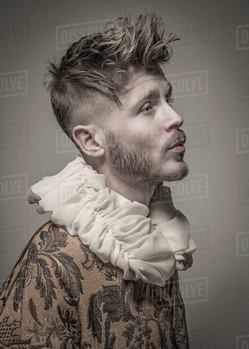 Studio portrait of a young man in profile wearing a jacket with a ...