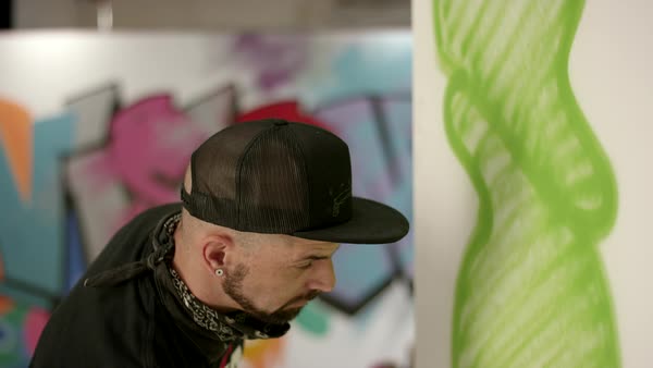 Graffiti artist spray painting at studio. - Stock Video Footage - Dissolve