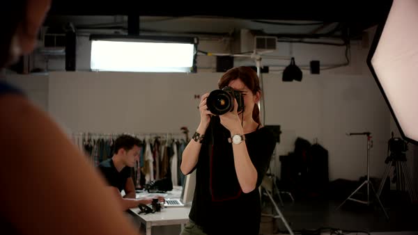 Female photographer photographing fashion model at studio. - Stock ...