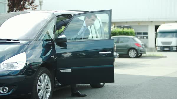Businessman getting out of minivan - Stock Video Footage - Dissolve