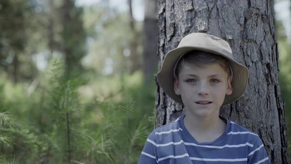 Boy leaning against tree trunk portrait - 4K Royalty-free Stock Video ...