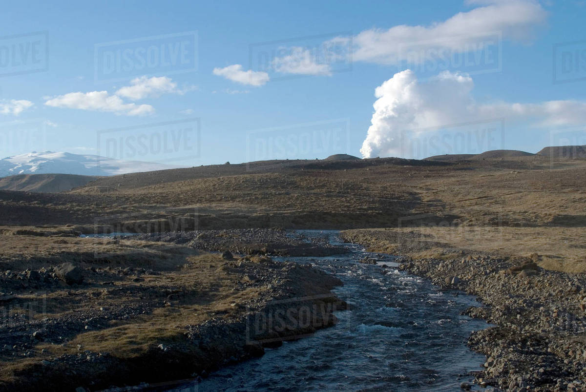 View of ash plume from Eyjafjallajokull volcano, from glacial run-off ...