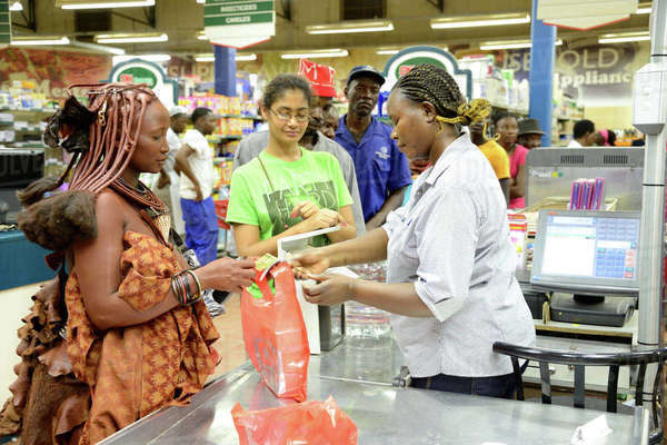 Himba woman in traditional clothing doing shopping at the supermaket ...