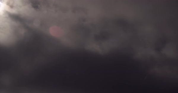 Close-up shot of dark stratus clouds drifting across blue sky, right to ...
