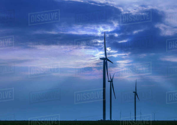 Wind turbine at sunset light, Moody Sky, clouds with sun rays - Royalty ...