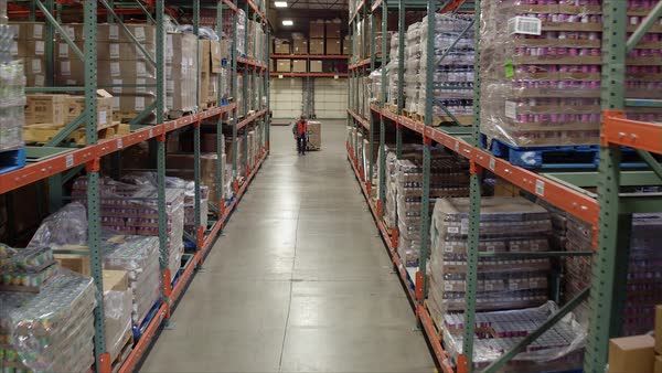 Worker pulling boxes in a warehouse - Stock Video Footage - Dissolve