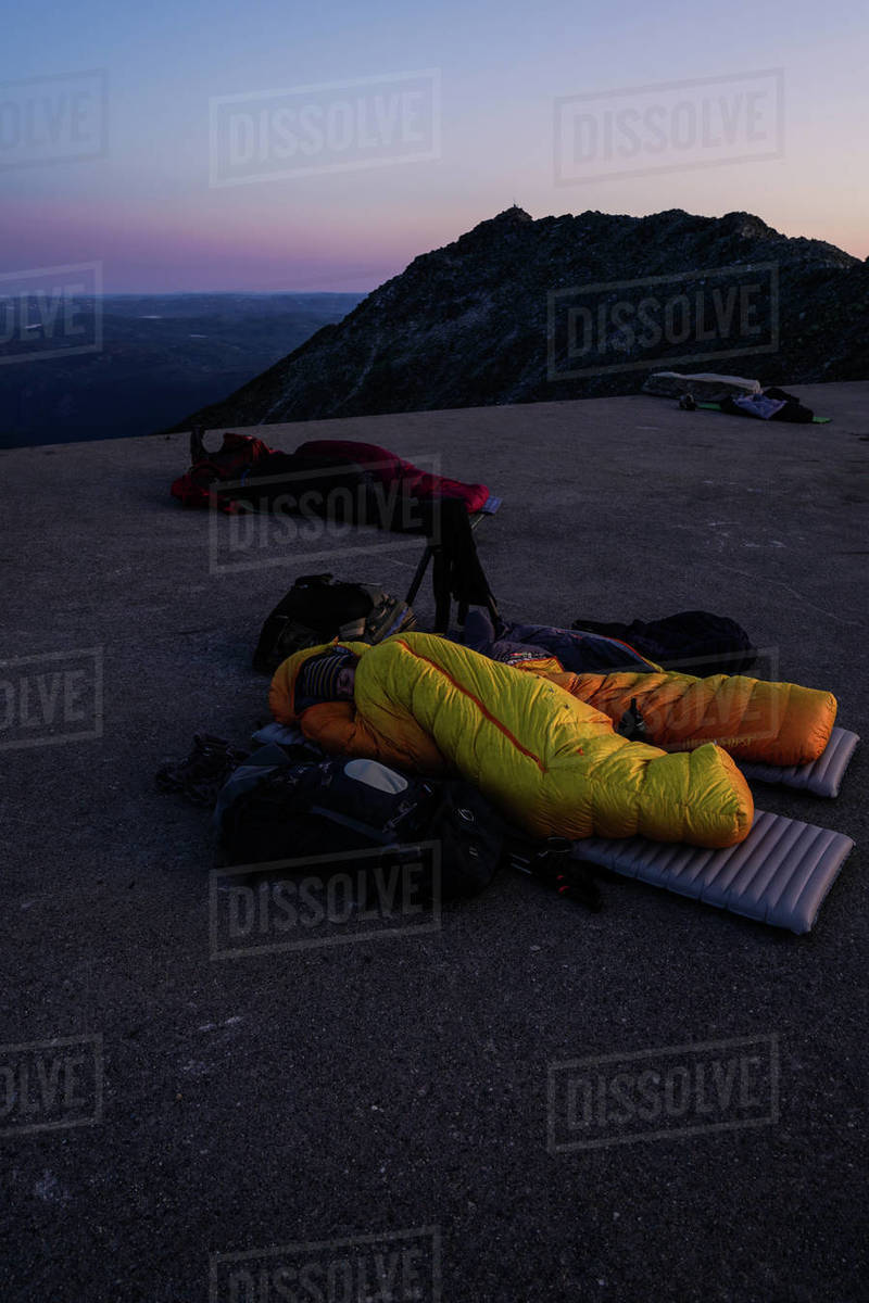 Woman sleeping on mountain at dawn - Royalty-free Stock Photo | Dissolve