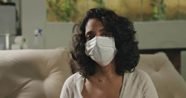 Covid 19 self isolation, woman at home wearing face mask protection ...