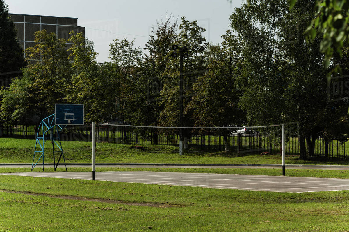 The school stadium. Volleyball net, basketball hoop. There is green ...