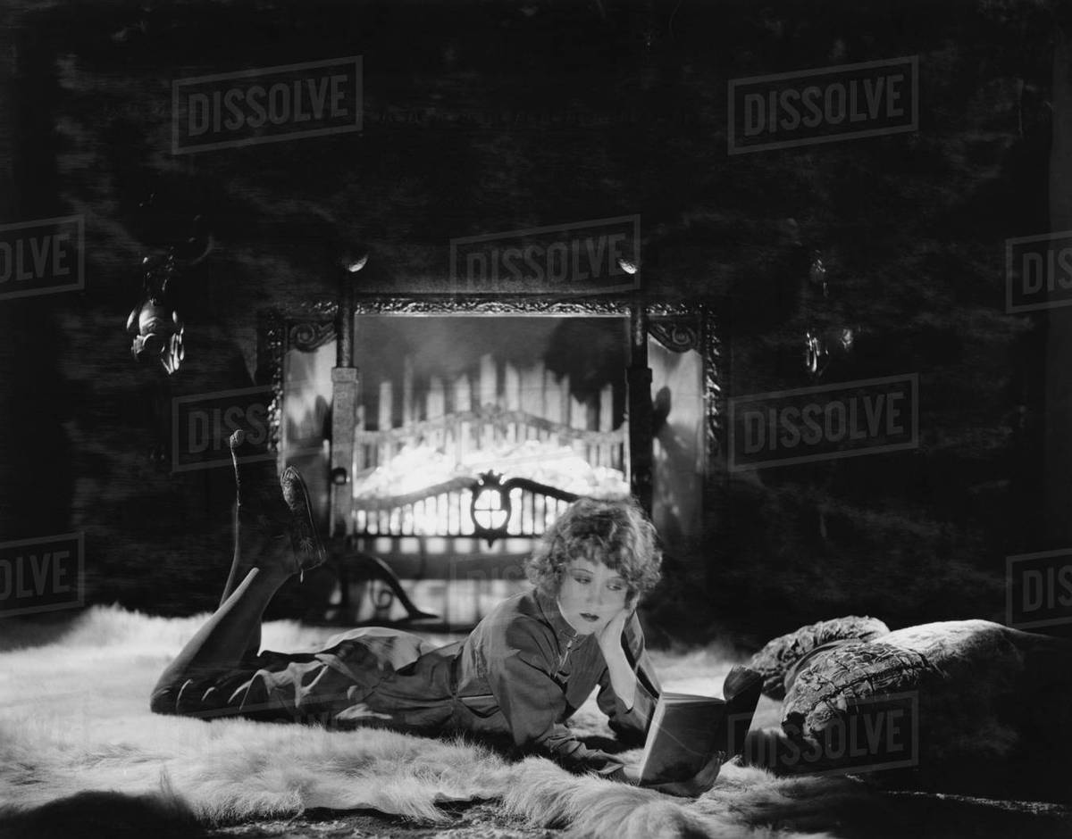 Woman reading book by the fire - Royalty-free Stock Photo | Dissolve