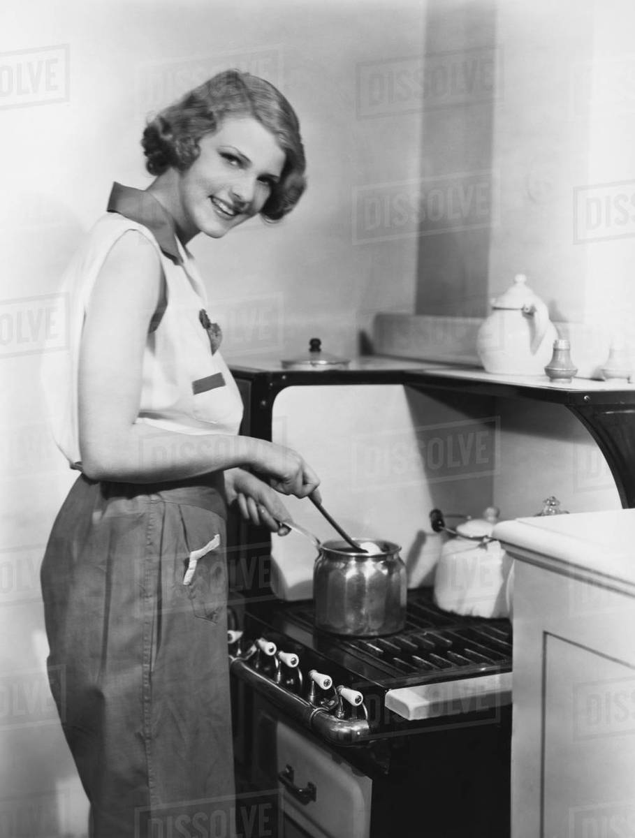 Portrait of woman cooking at stove - Stock Photo - Dissolve