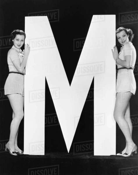 Two women posing with huge letter M - Royalty-free Stock Photo | Dissolve