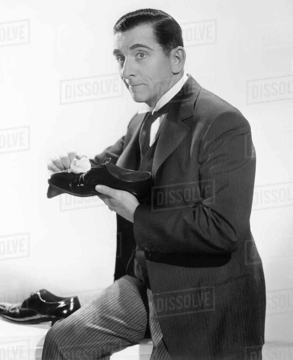 Man cleaning shining shoes - Stock Photo - Dissolve