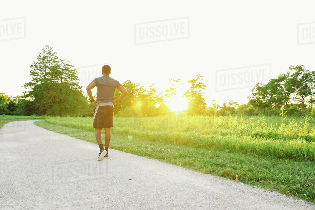 Man walking on path in park - Royalty-free Stock Photo | Dissolve