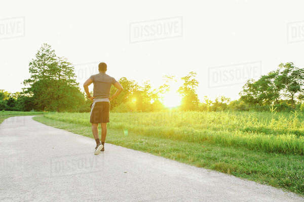 Man walking on path in park - Royalty-free Stock Photo | Dissolve