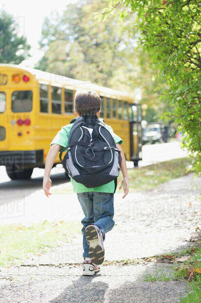 Caucasian boy running after school bus - Royalty-free Stock Photo ...