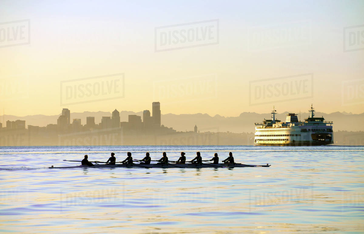 Team rowing boat in bay - Royalty-free Stock Photo | Dissolve