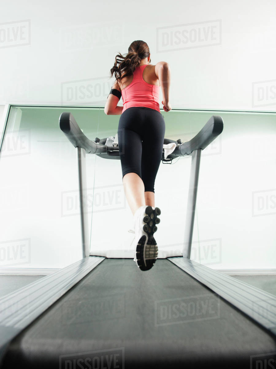 Mixed race woman running on treadmill - Royalty-free Stock Photo | Dissolve