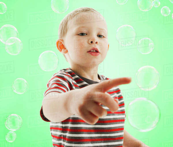 Caucasian boy popping bubbles - Royalty-free Stock Photo | Dissolve