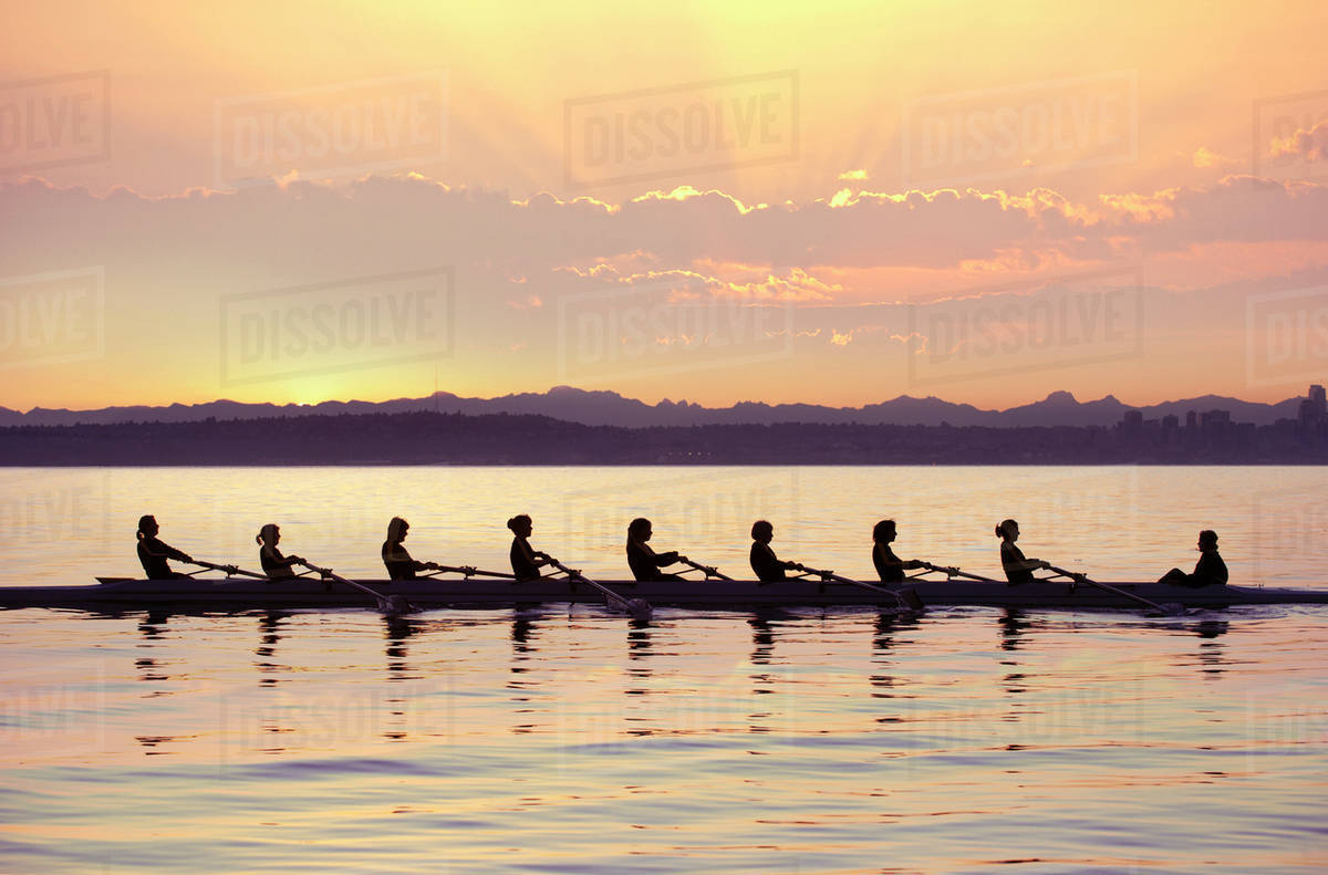Team rowing boat in bay - Royalty-free Stock Photo | Dissolve