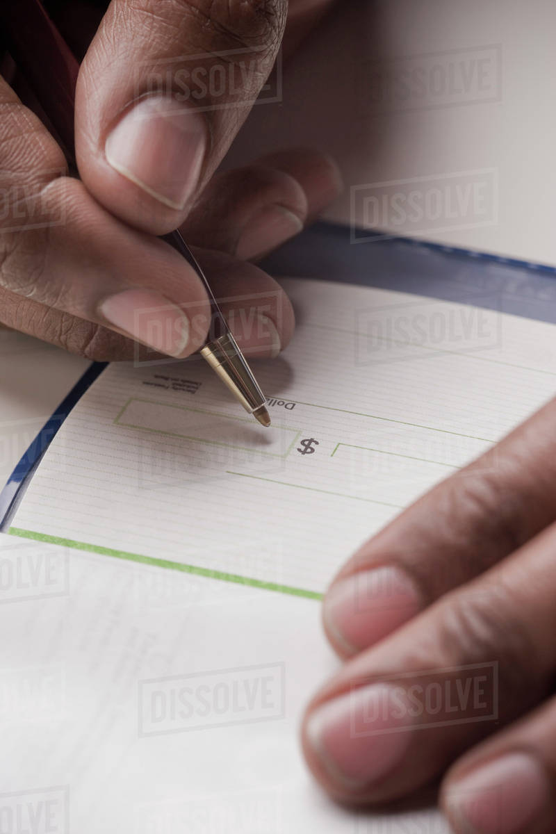 Mixed race man writing a check - Royalty-free Stock Photo | Dissolve